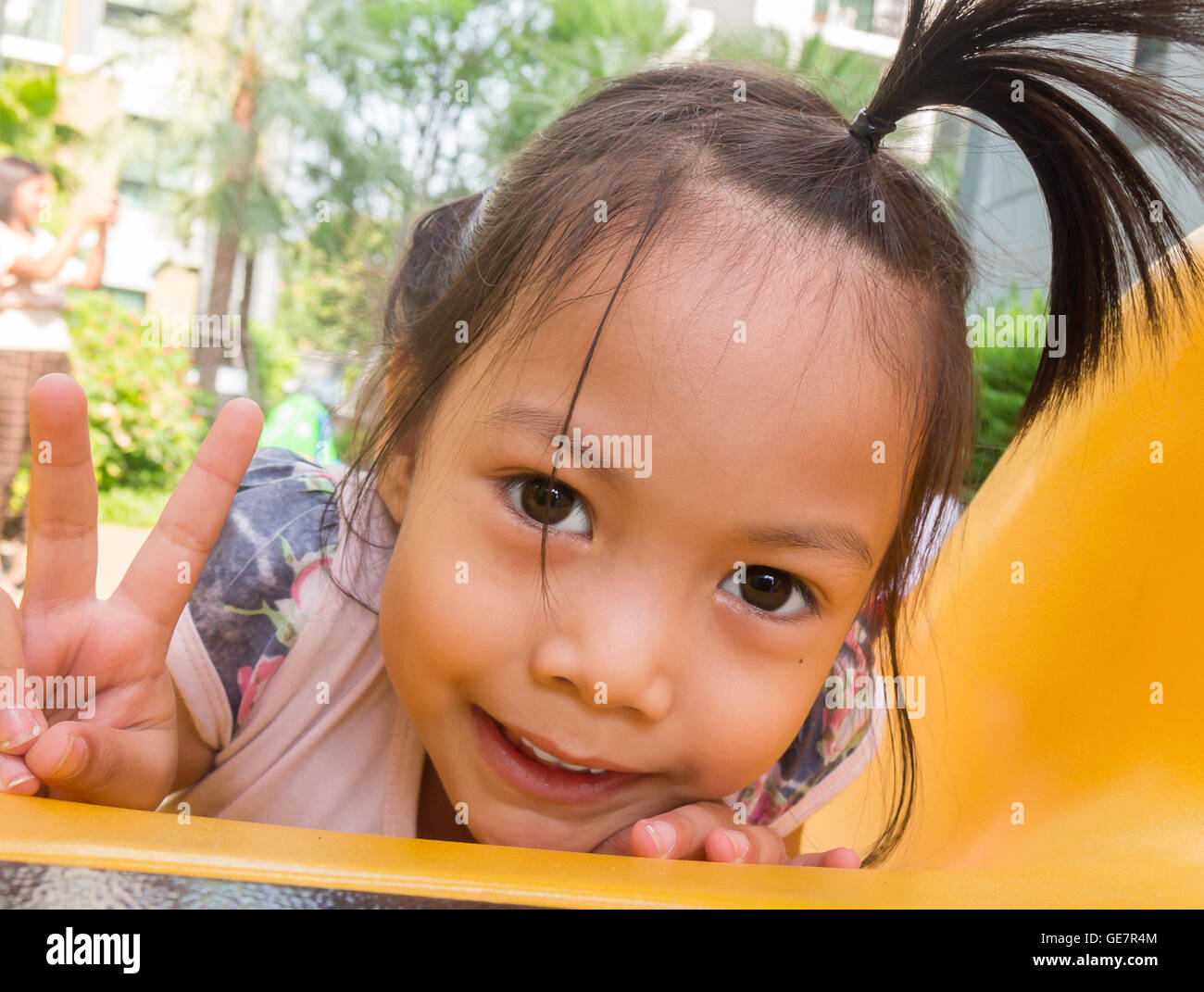 Little cute asian kids playing in slider at a park on a bright sunny ...