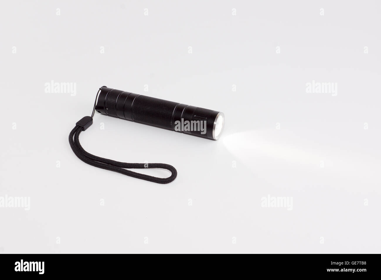 small working flashlight on a white background with a beam of light ...
