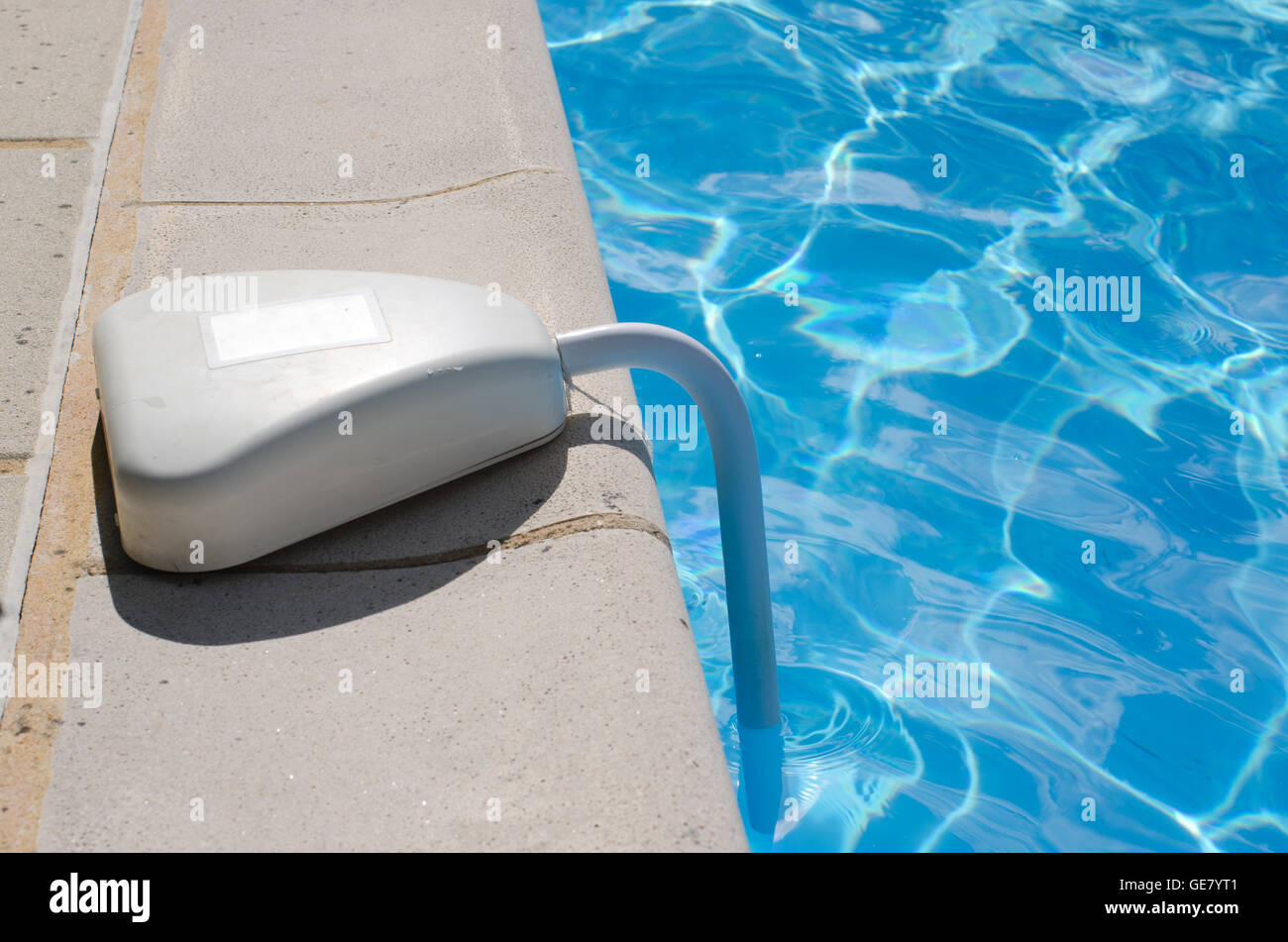 Swimming pool alarm positioned on the side of a home swimming pool ...