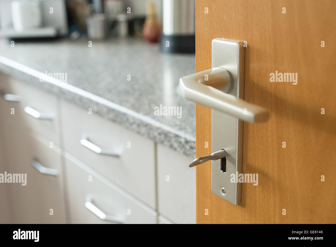 Wooden door with handle and key of a kitchen with cupboard and ...