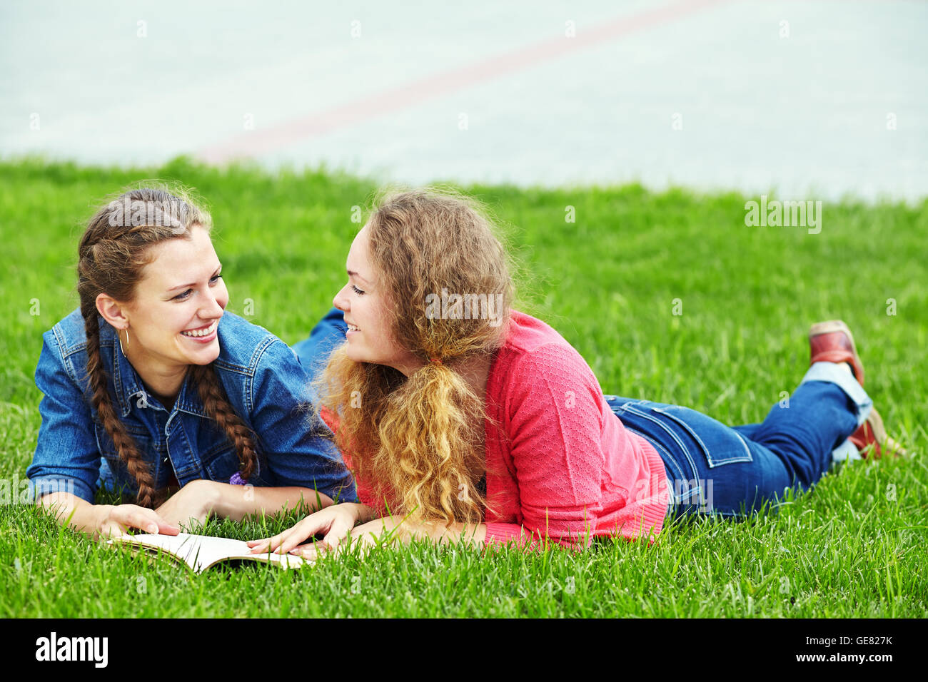 two girlfriends reading a book Stock Photo - Alamy