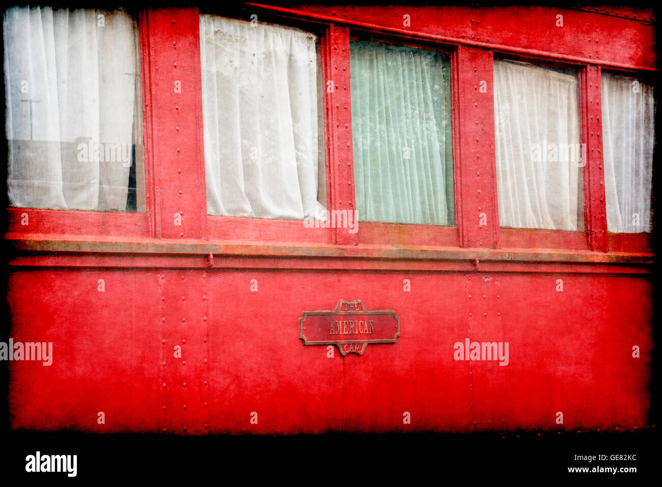 A weathered & Vintage red passenger train car with white curtains ...