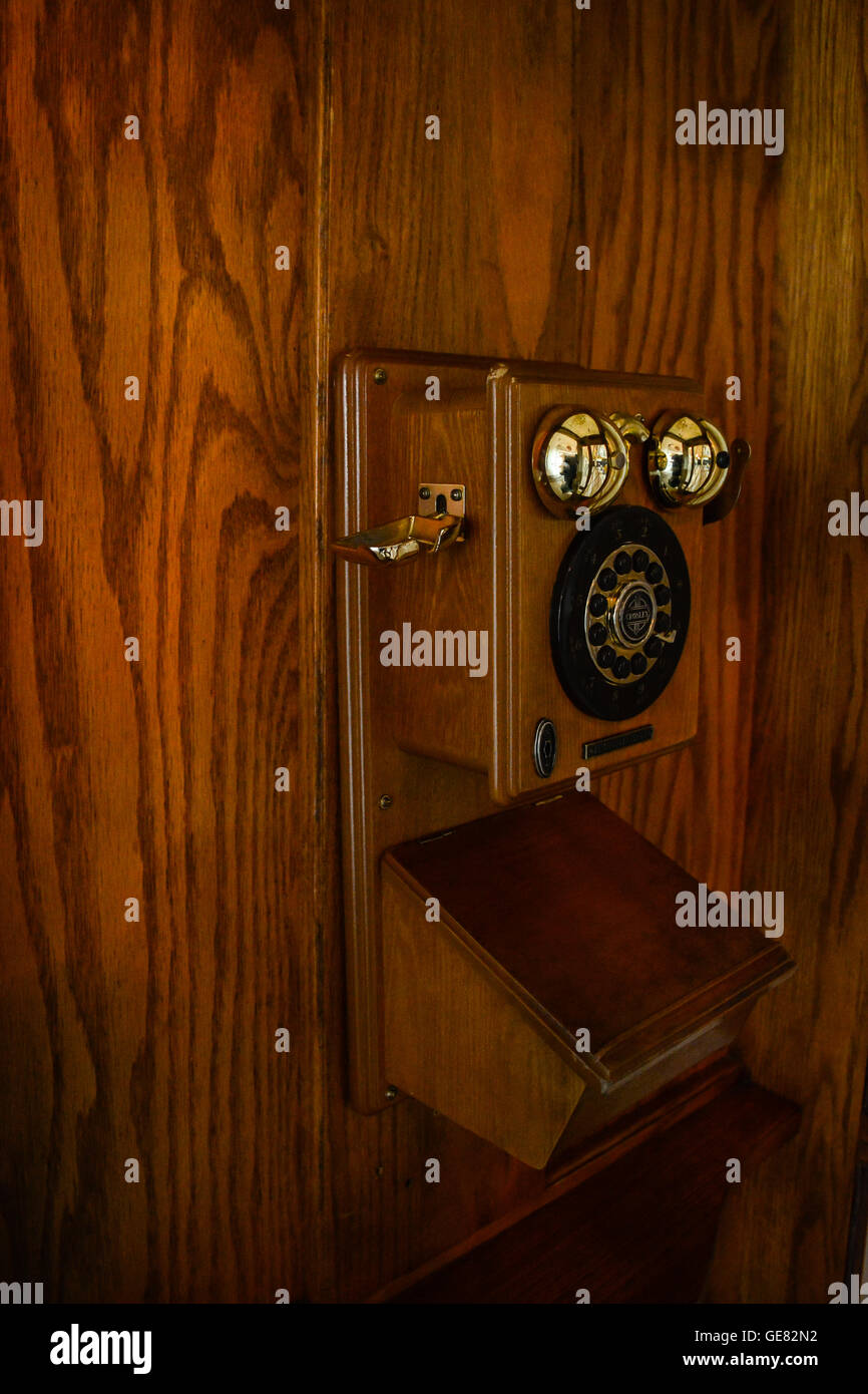 A moody and nostalgic view Inside a vintage wooden pay telephone booth ...