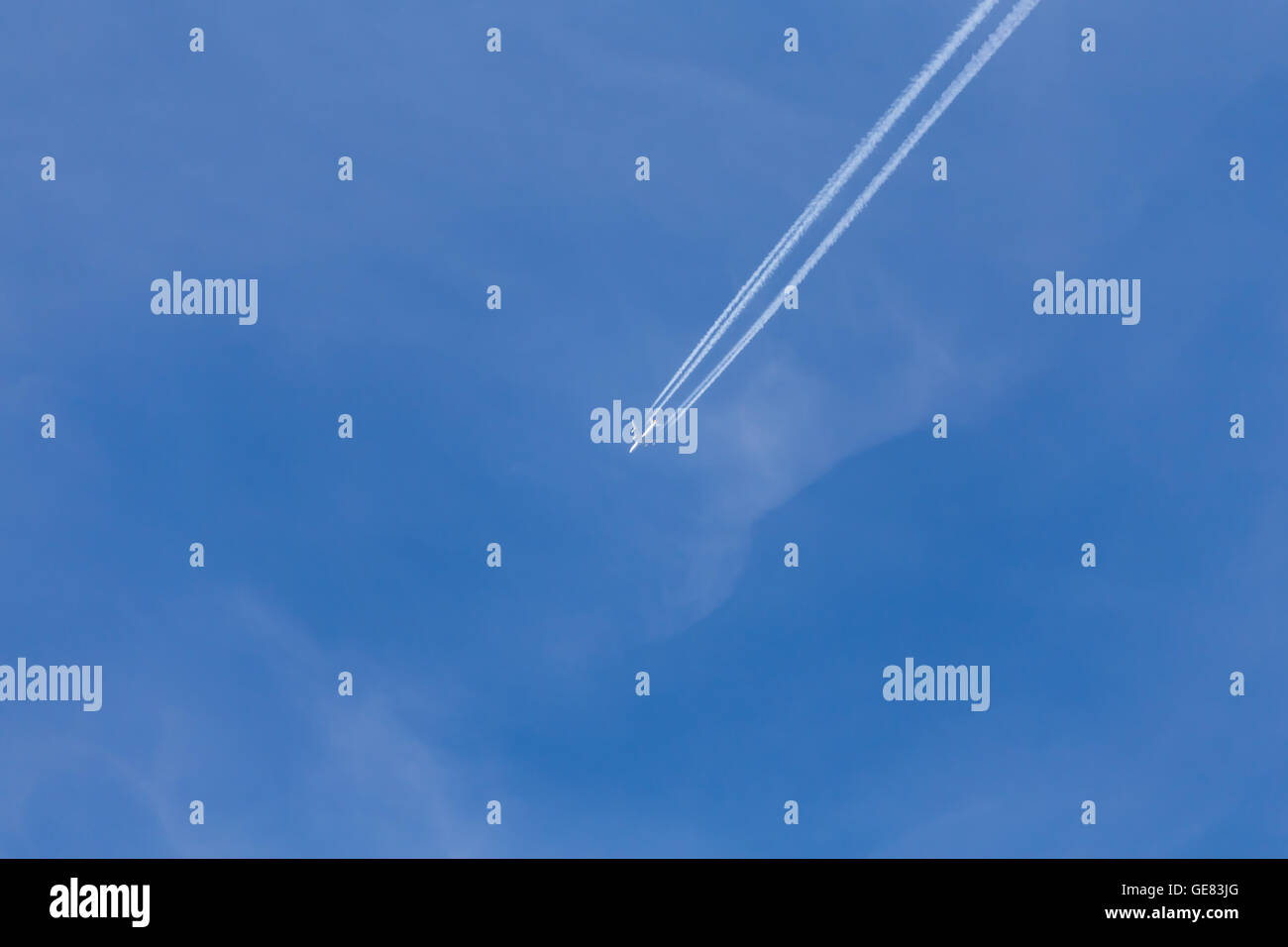 Shot of long trail of jet plane on blue sky Stock Photo - Alamy