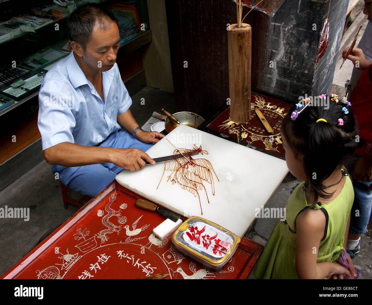 An artisan candy maker fashions a bird from sugar candy in Ciqikou ...
