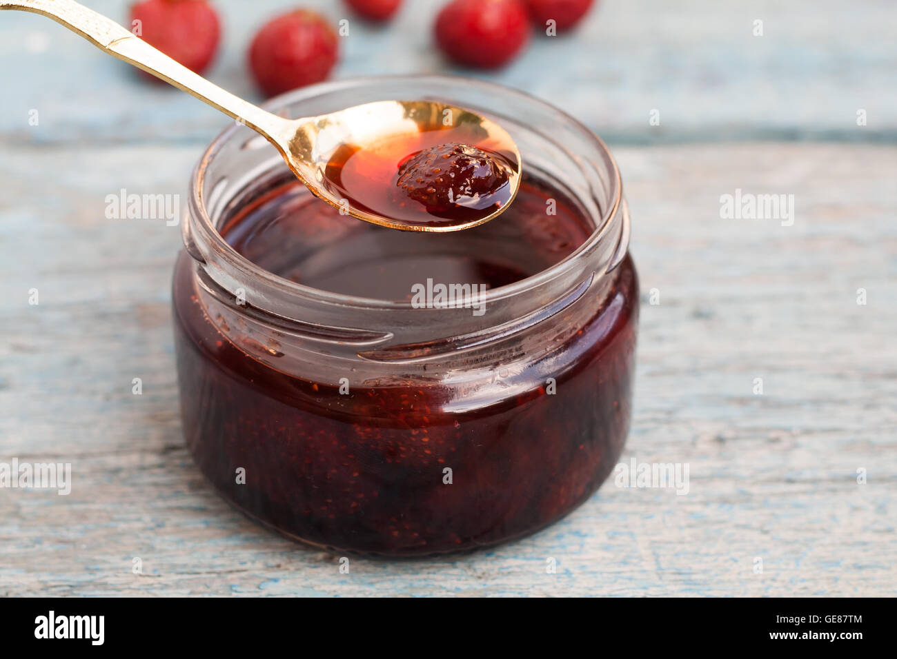 liquid strawberry jam in a jar with a spoon Stock Photo - Alamy