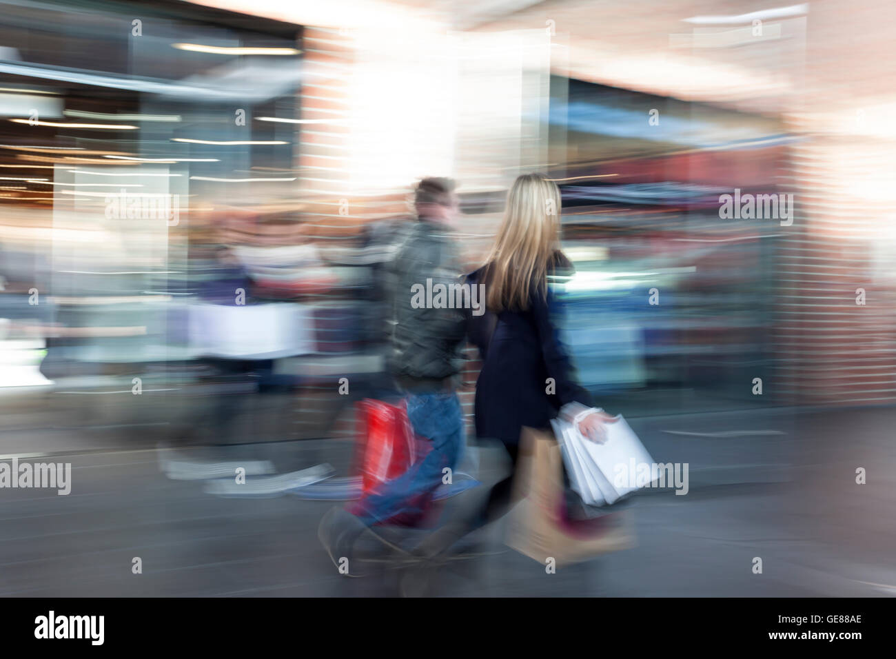 Shopper walking against shop window Stock Photo - Alamy