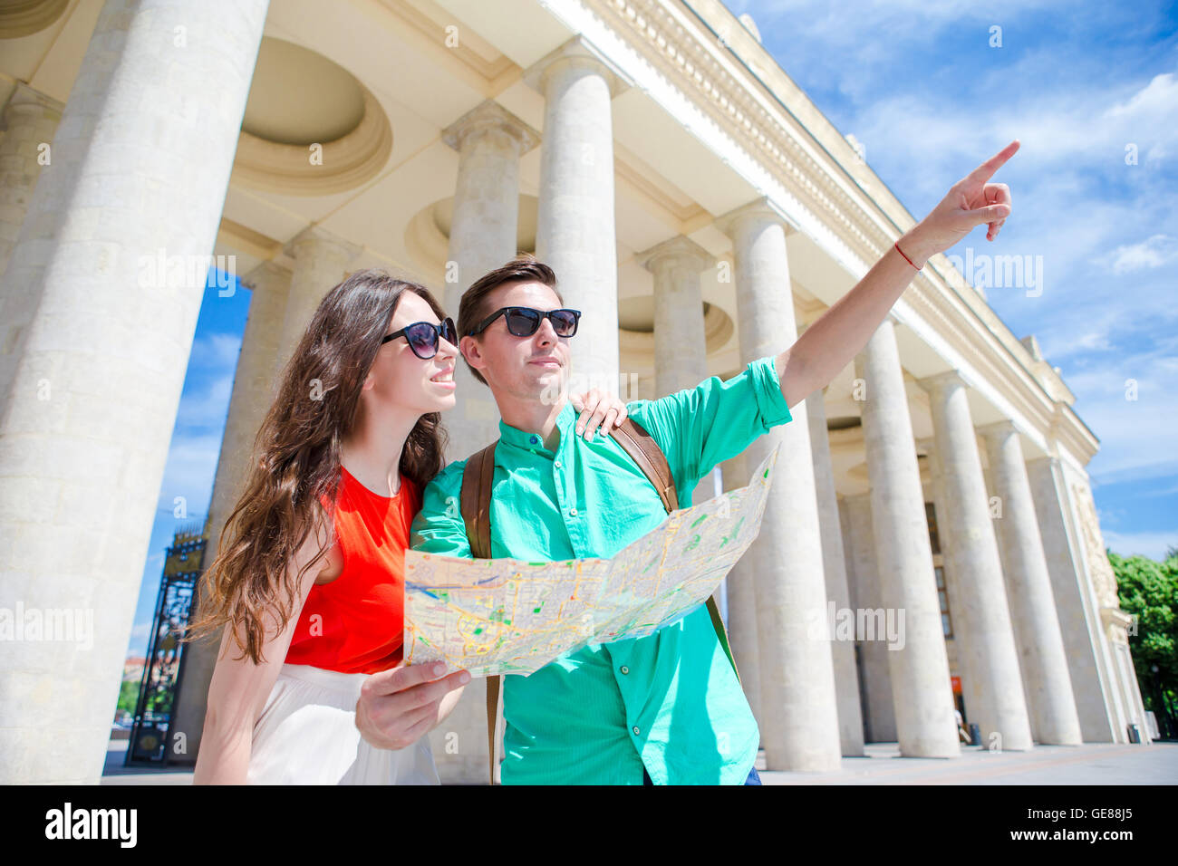 Romantic couple together with city map outdoors. Happy lovers enjoying ...