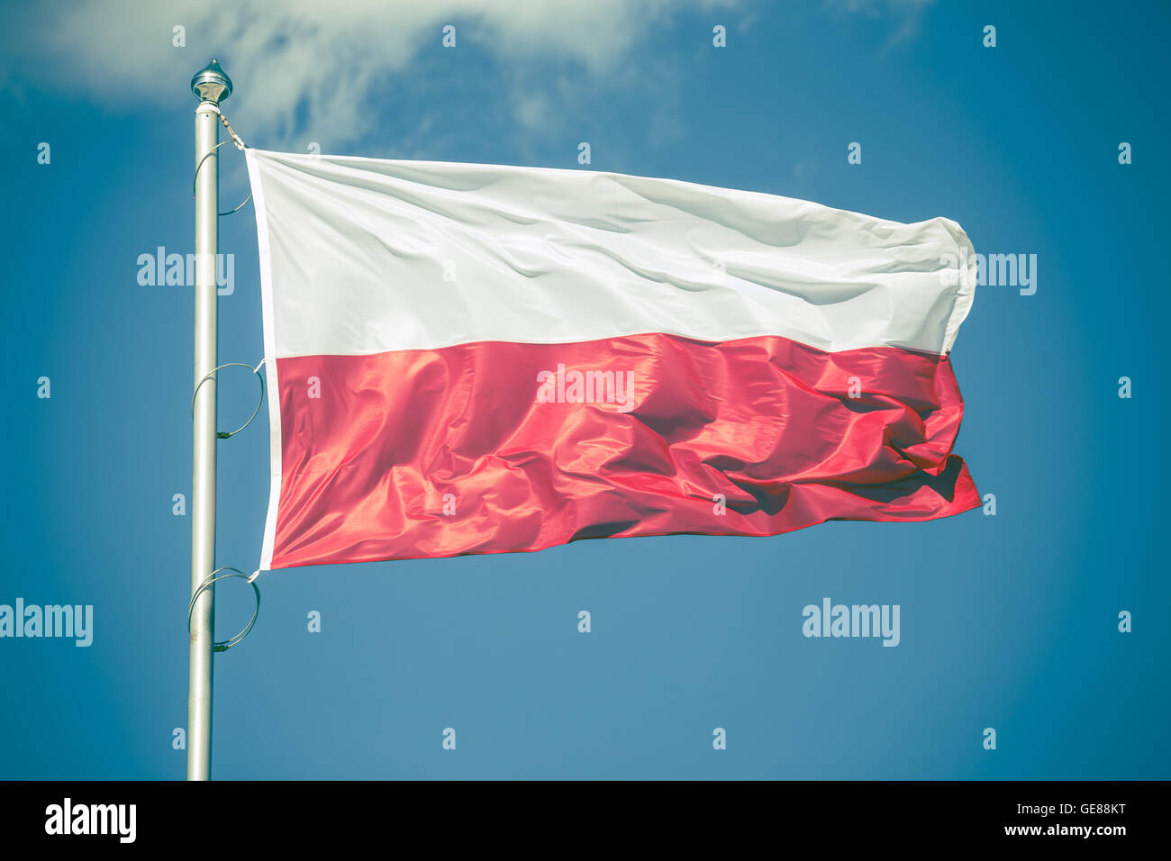 Polish flag on blue sky background, vintage look Stock Photo - Alamy