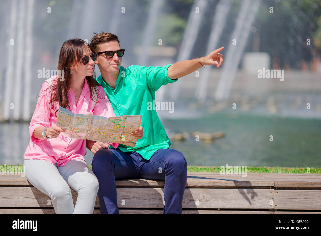 Romantic couple together with city map outdoors. Happy lovers enjoying ...