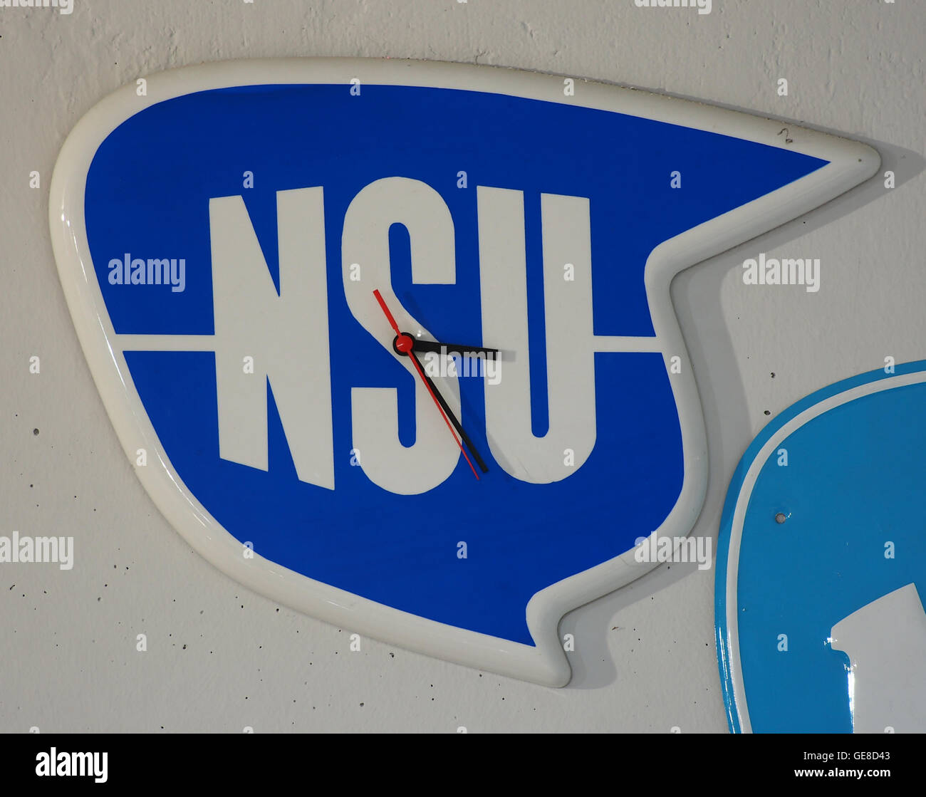 This NSU Autodienst advertisement features a clock and enamel sign ...