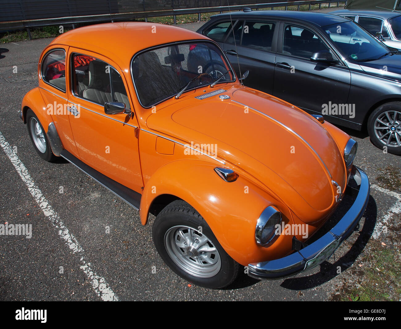 This photograph features a 1972 Volkswagen Beetle (Kever) in orange. The classic car is captured ...
