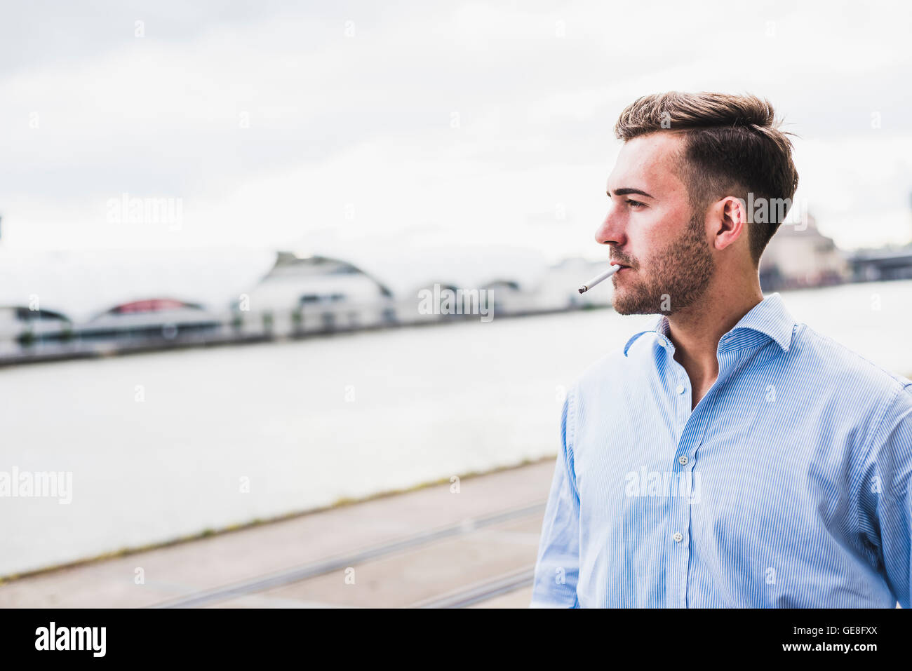 Young man smoking a cigarette Stock Photo - Alamy