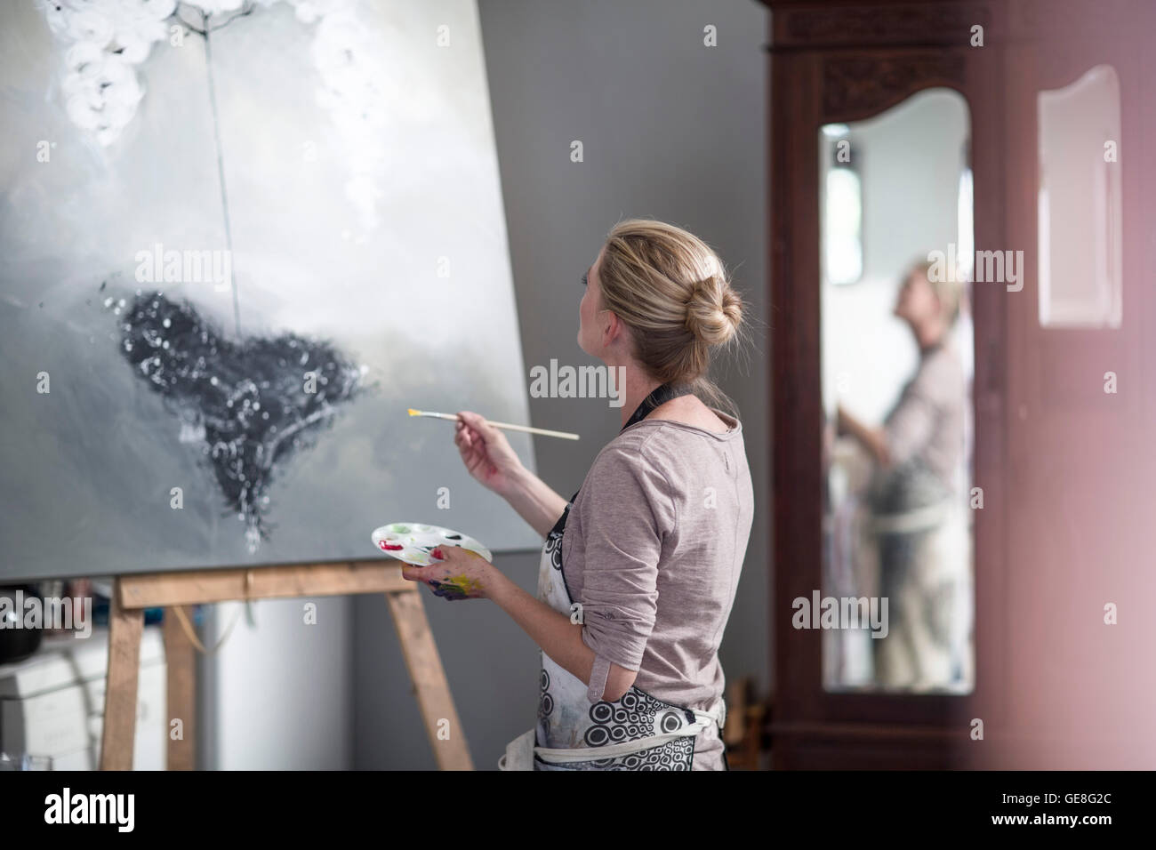 Female painter painting on canvas Stock Photo - Alamy