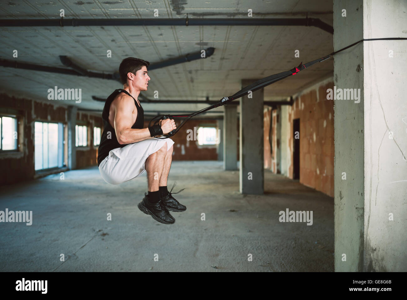 Young man exercising suspension training trx, jumping Stock Photo - Alamy