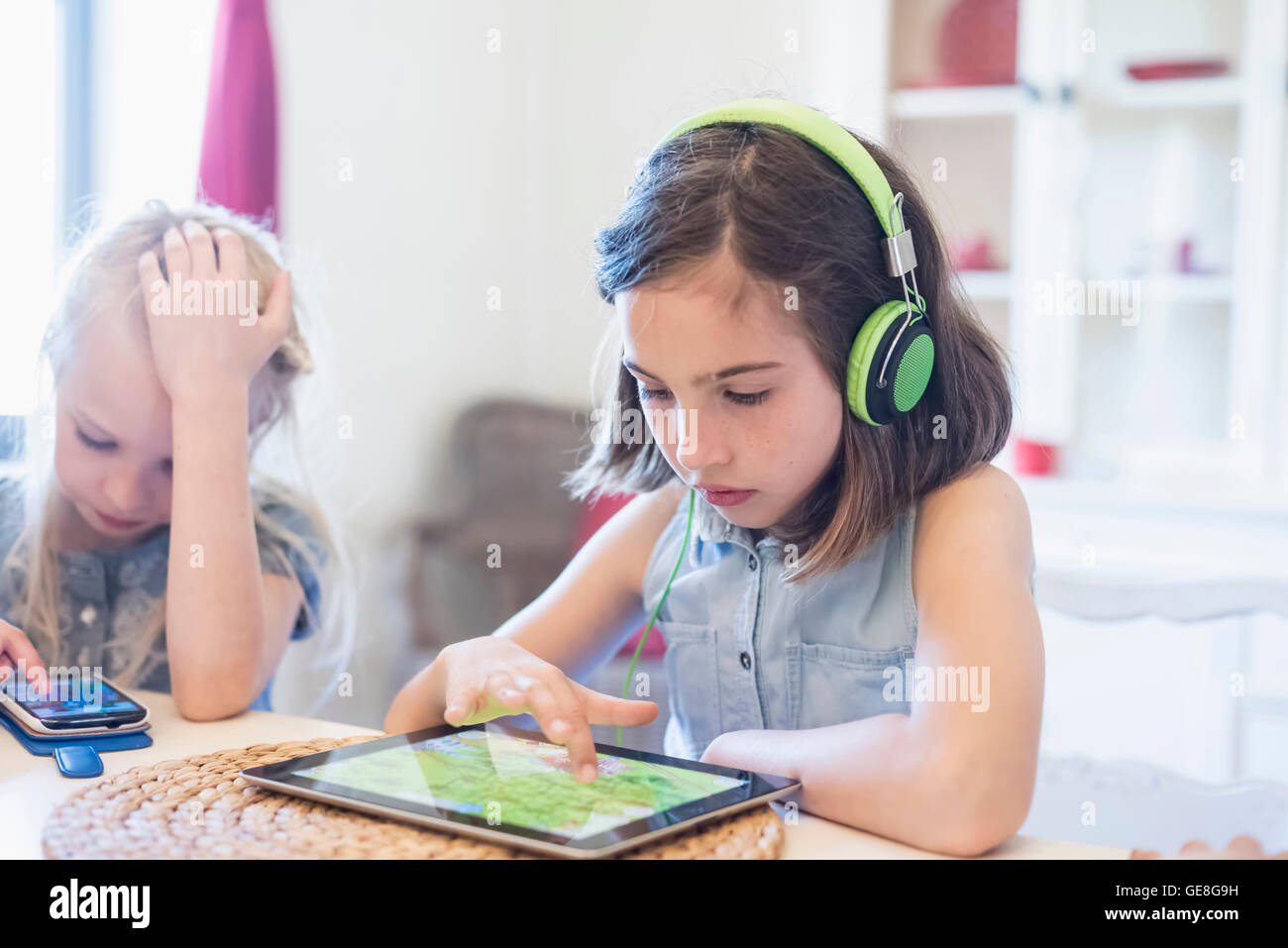 Two girls using mobile devices Stock Photo - Alamy