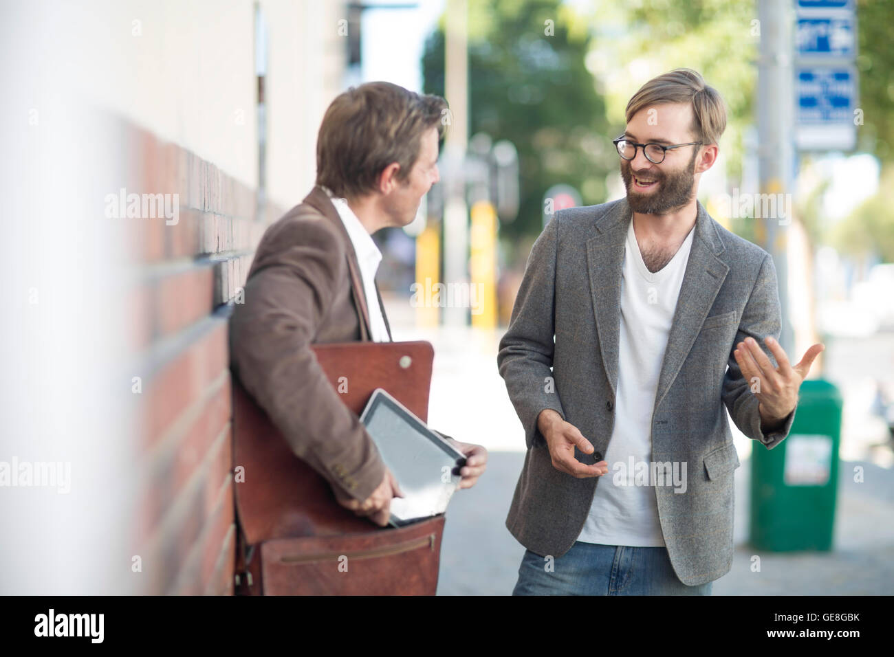 Two men talking in city Stock Photo - Alamy