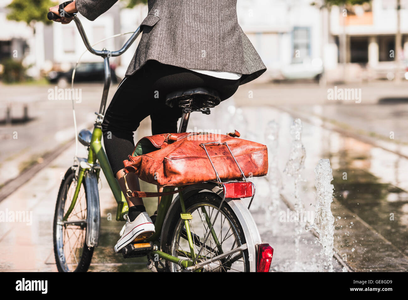Back view of woman riding bicycle, partial view Stock Photo - Alamy