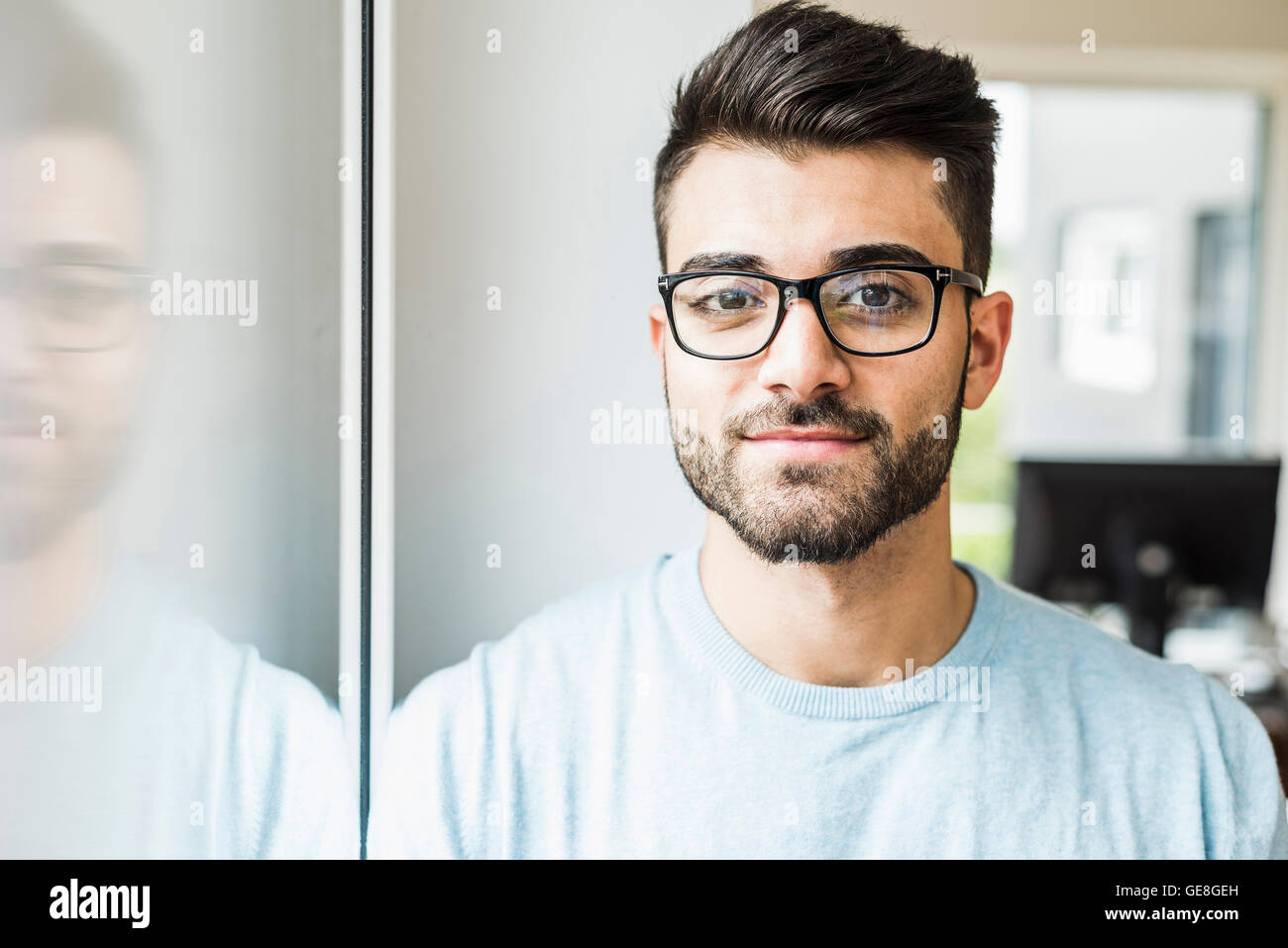 Portrait of smiling young man at the window Stock Photo - Alamy