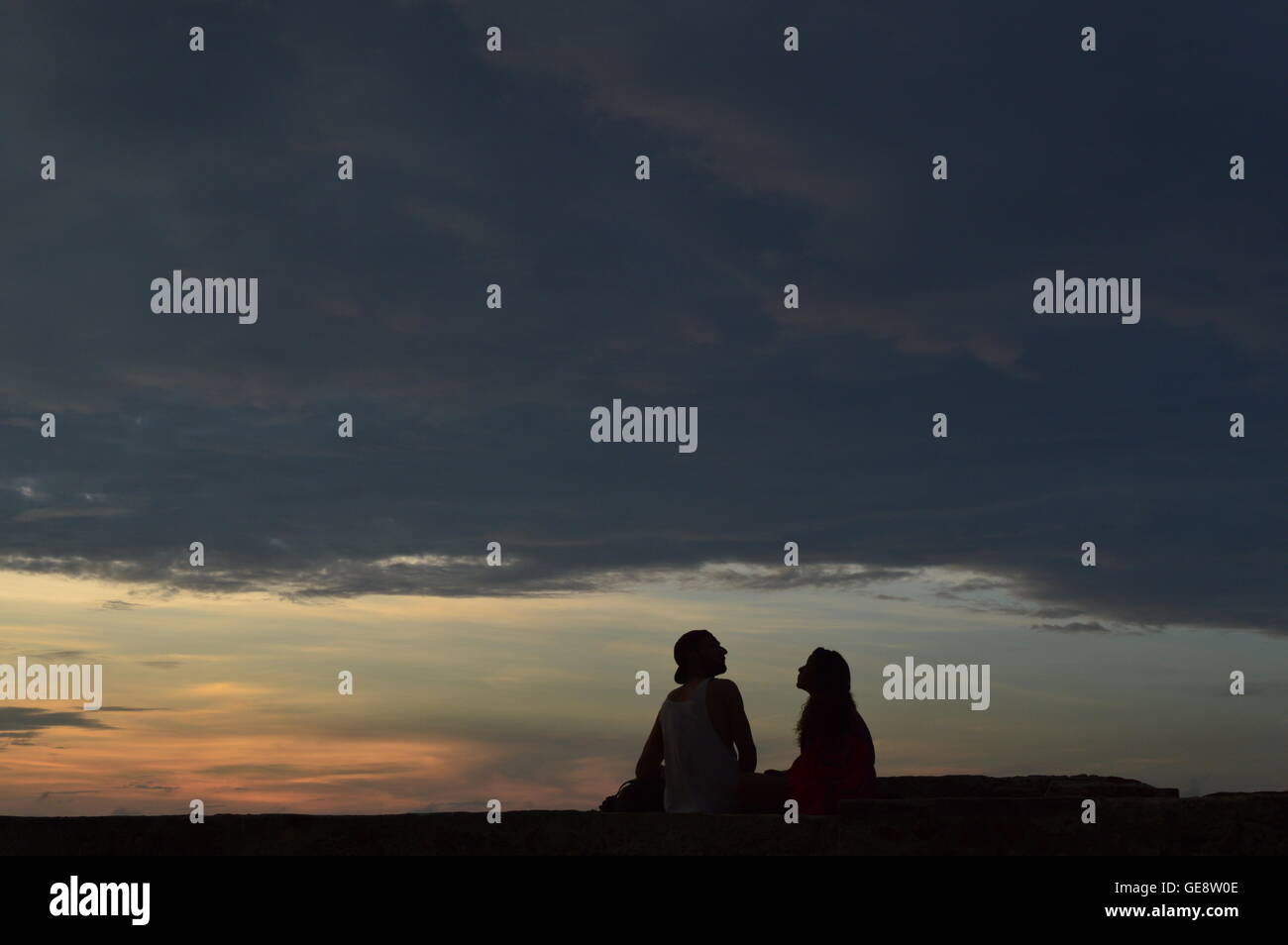 Couple watching the sunset Stock Photo - Alamy
