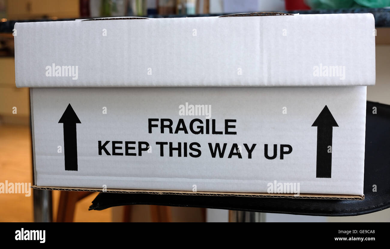 End of a packaging box with a Fragile Keep this way up sign with arrows ...