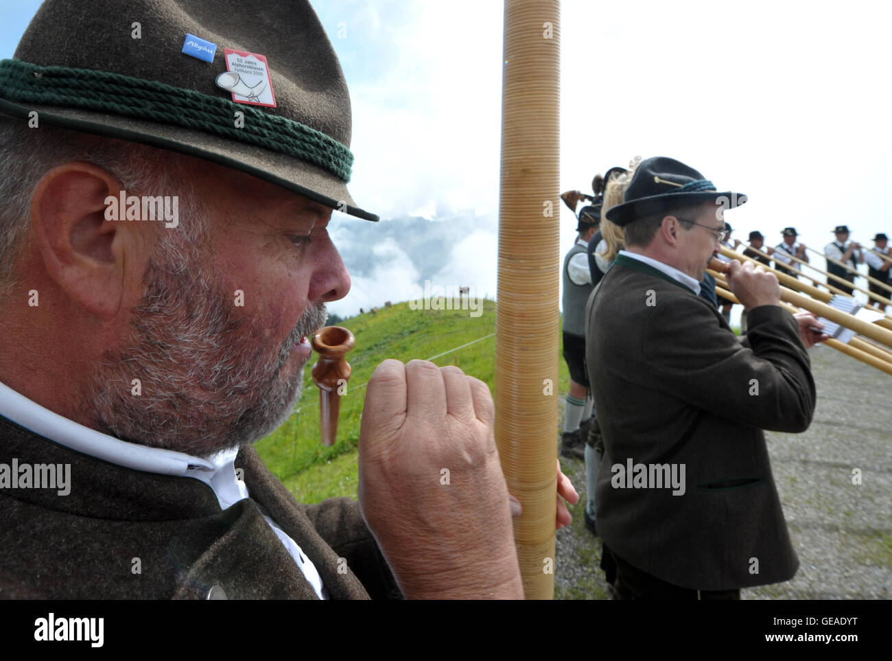 A Alphornblaeser (traditional Alpine horn blower) moistens his ...