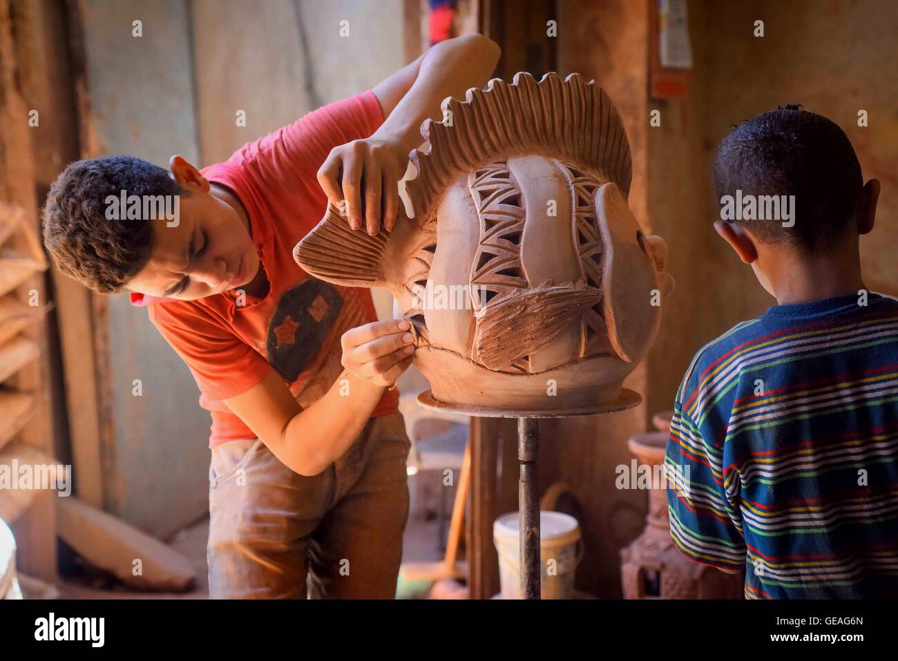 Cairo, Egypt. 24th July, 2016. An Egyptian boy works at a pottery ...