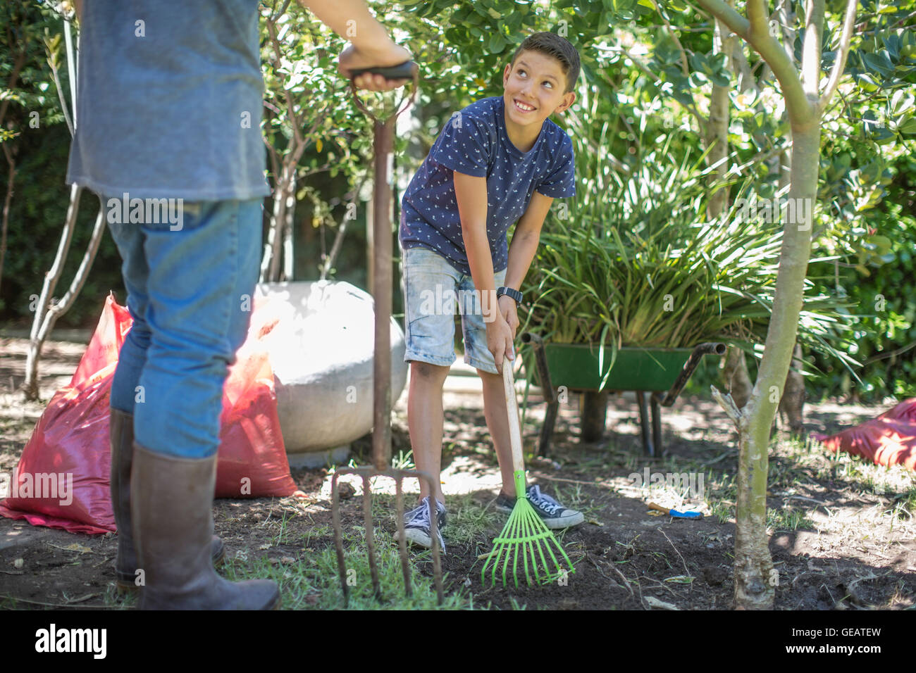 Father and son working in garden together Stock Photo - Alamy