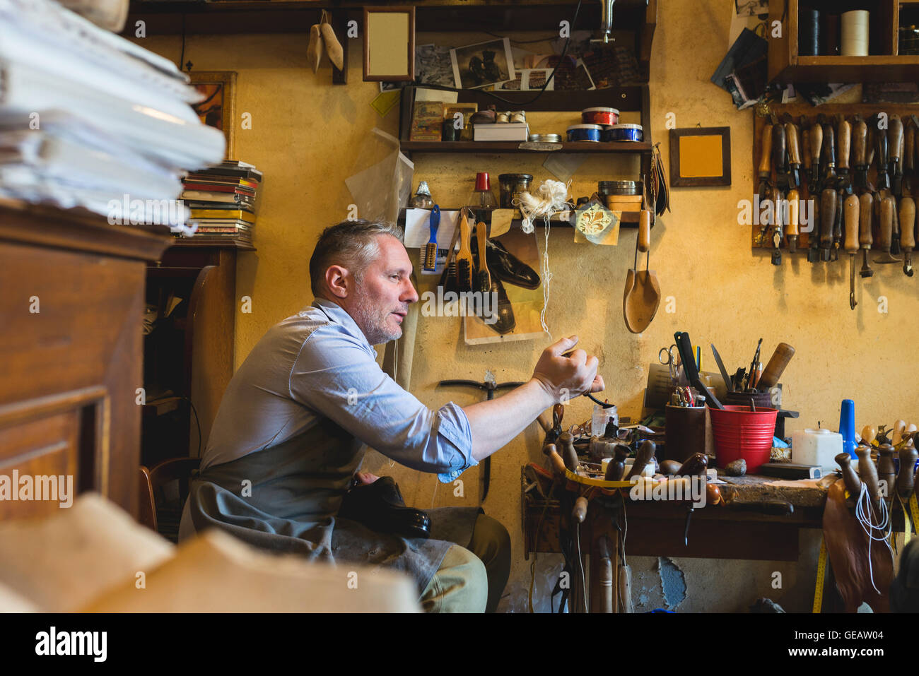 Cobbler making shoes in his workshop Stock Photo - Alamy