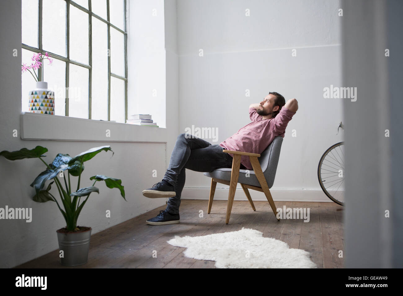 Man sitting in chair daydreaming Stock Photo - Alamy