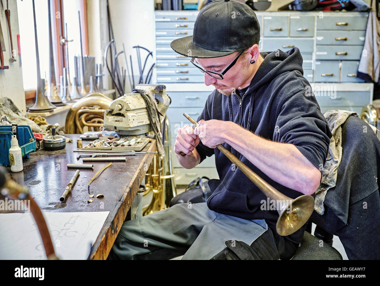 Instrument maker making trumpet in workshop Stock Photo - Alamy
