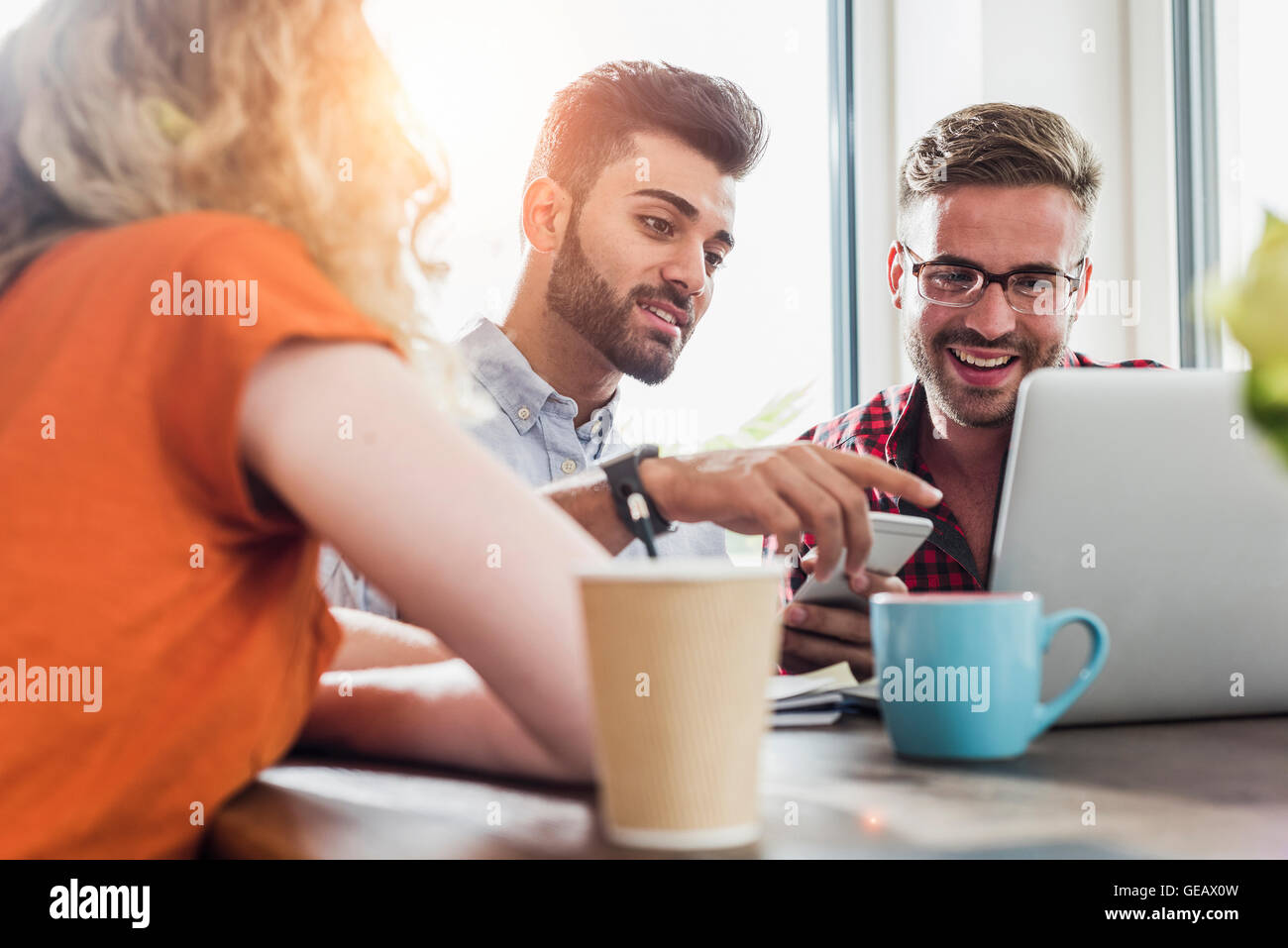 Young professionals working on laptop in office Stock Photo - Alamy
