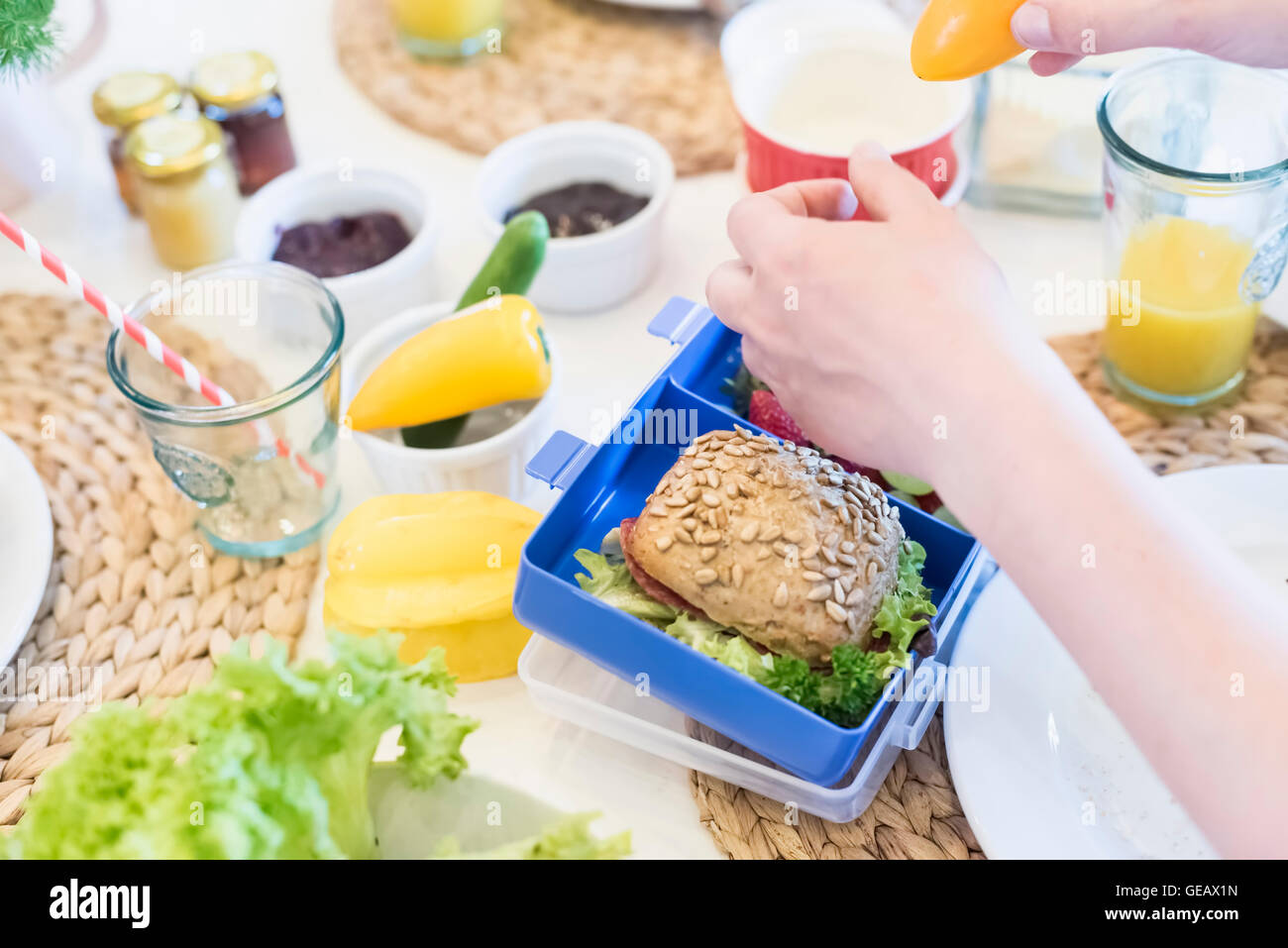Boy packing lunch box with healthy food Stock Photo - Alamy
