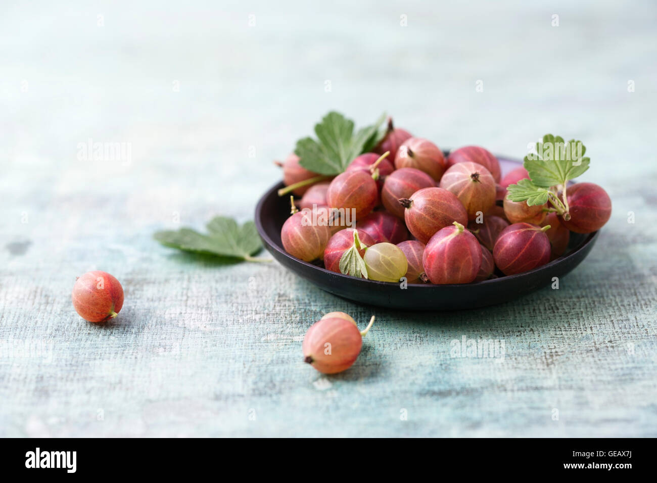 Bowl of red gooseberries Stock Photo - Alamy