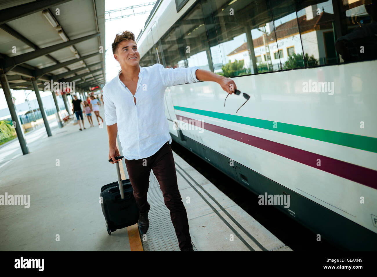 Young man at station platform running to get on the train Stock Photo ...