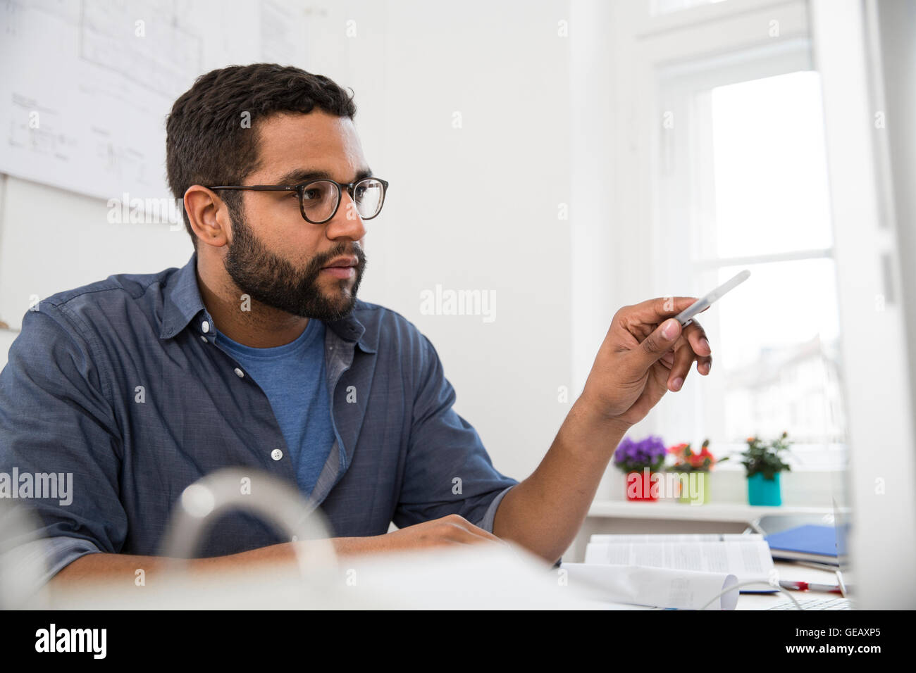 Young man working at desk in office Stock Photo - Alamy