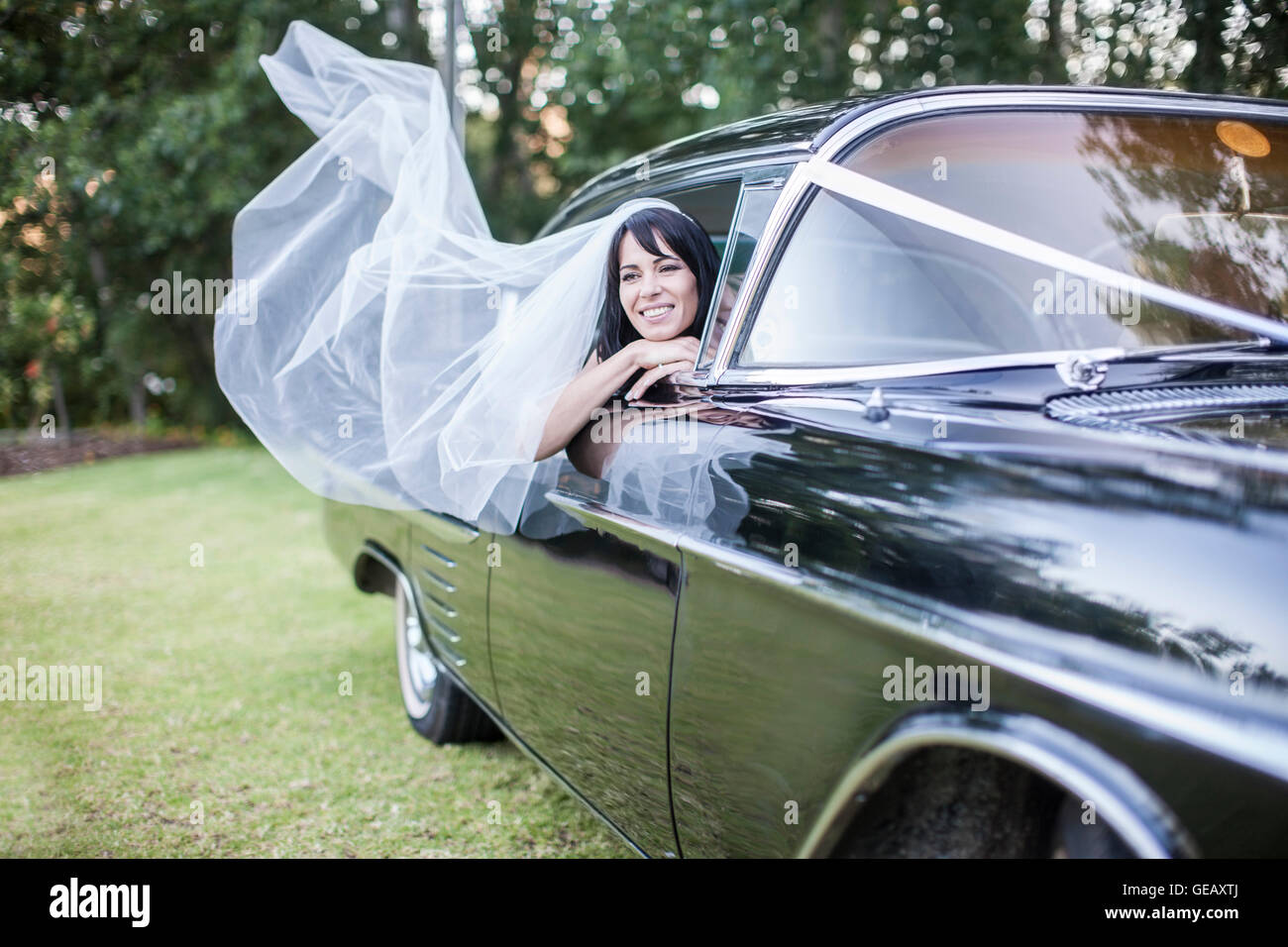 Smiling bride sitting in vintage car Stock Photo - Alamy