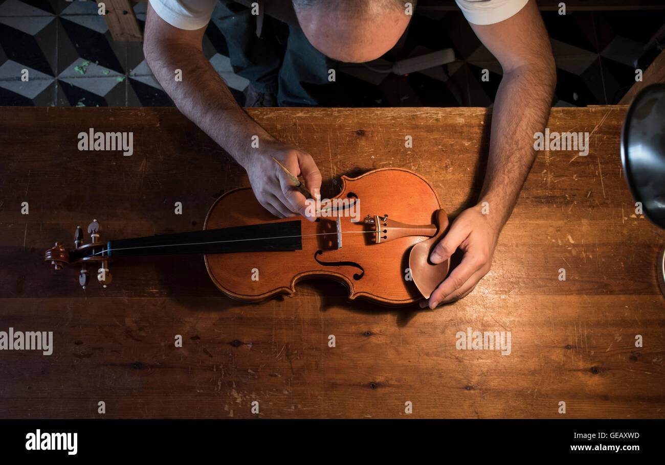 Luthier adjusting the sound post of a violin in his workshop Stock ...