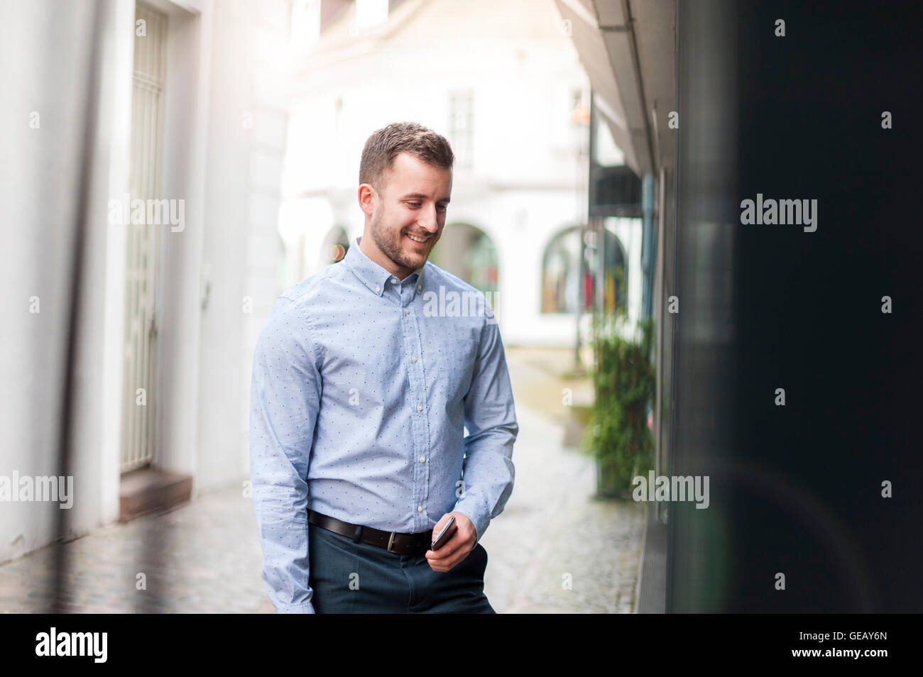 Young man looking in shop window Stock Photo - Alamy