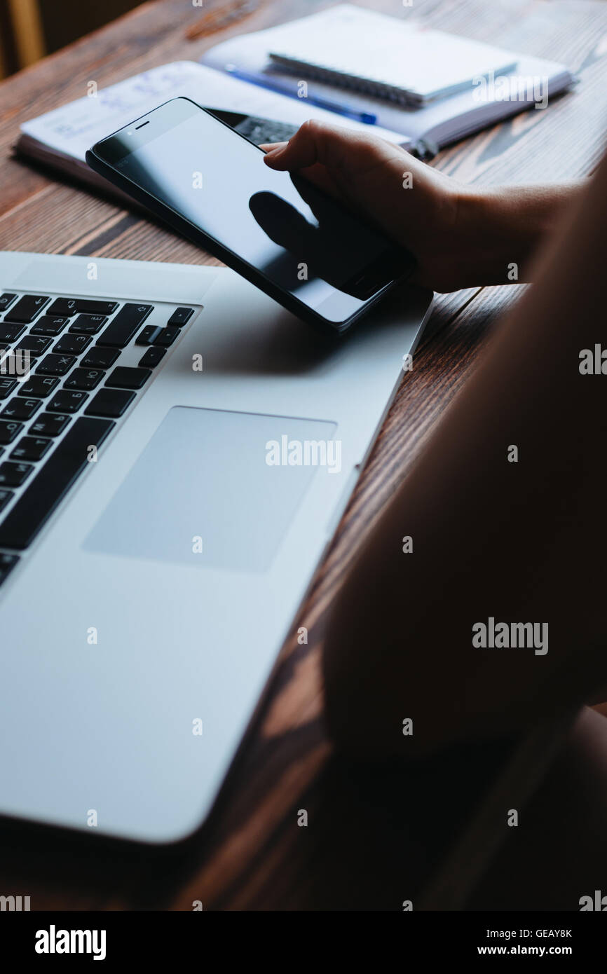 Woman working on computer and looking at the phone Stock Photo - Alamy