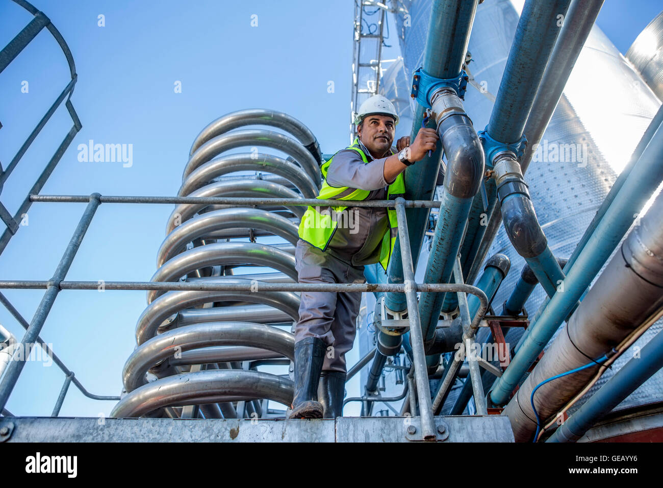 Worker controlling stainless steel tanks for food industry Stock Photo ...