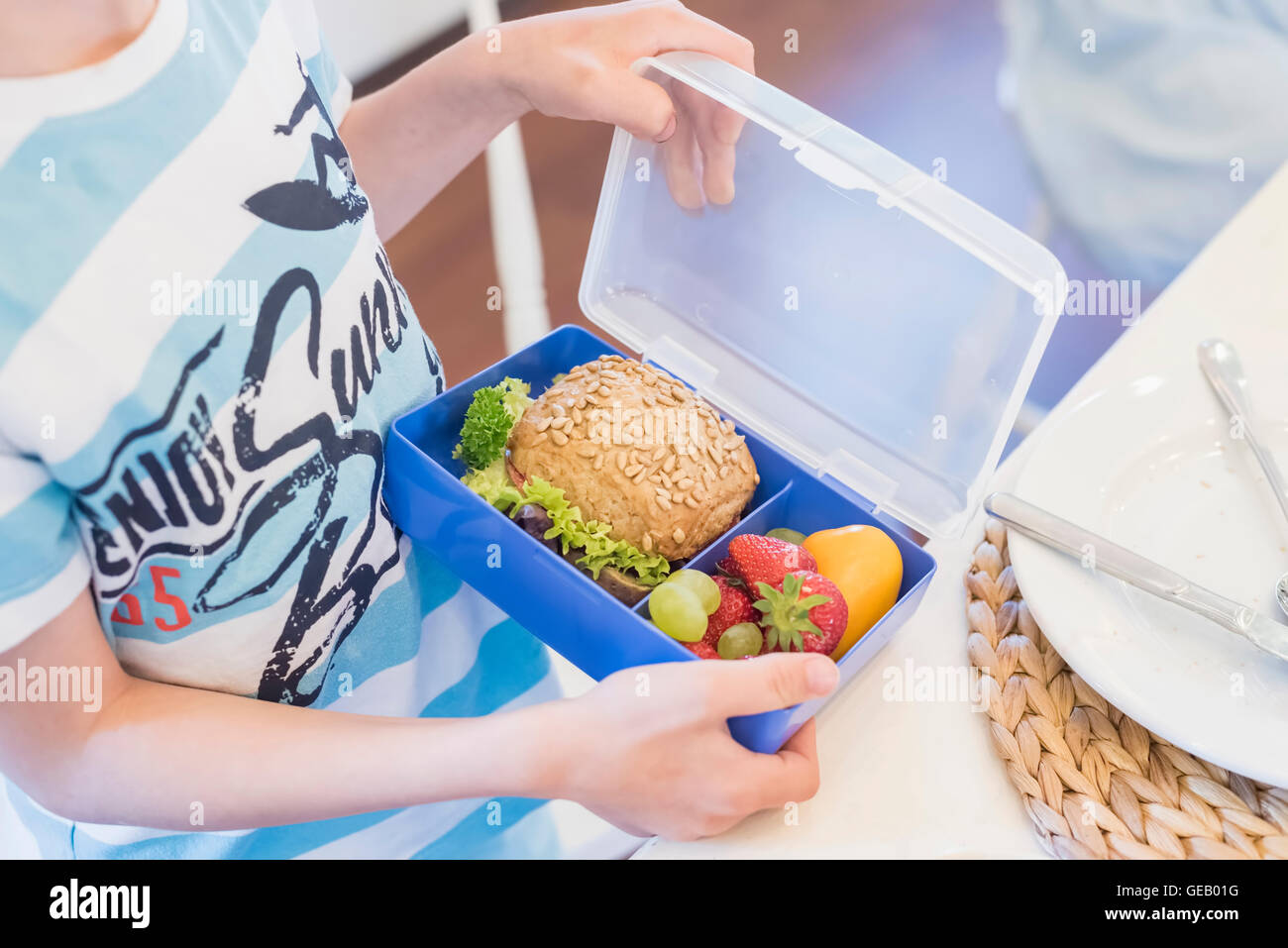 Boy packing lunch box with healthy food Stock Photo - Alamy