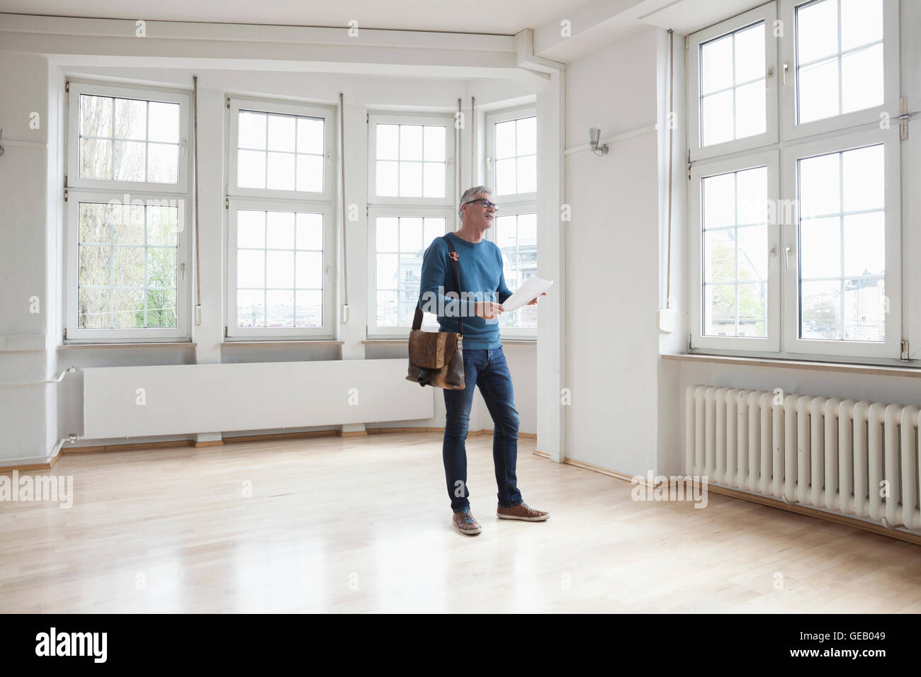 Man looking around in empty apartment Stock Photo - Alamy