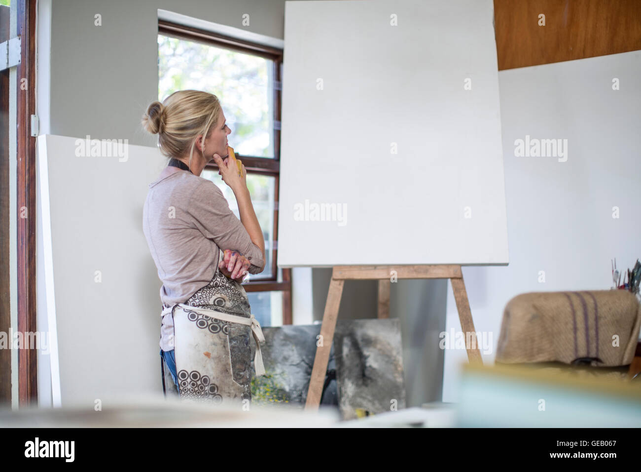 Woman observing canvas before setting up artwork at home studio Stock ...