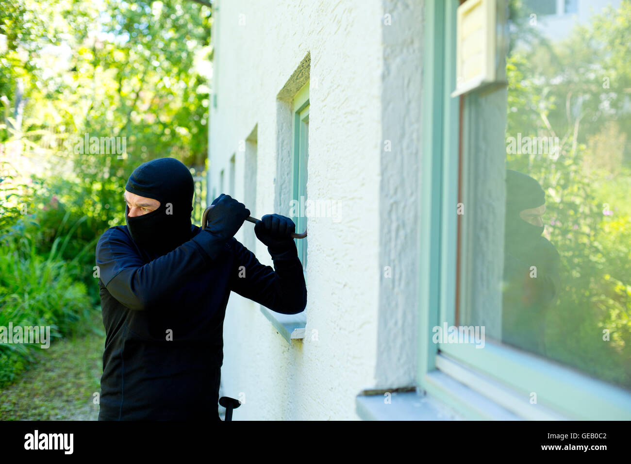 Burglar with crowbar breaking window Stock Photo - Alamy