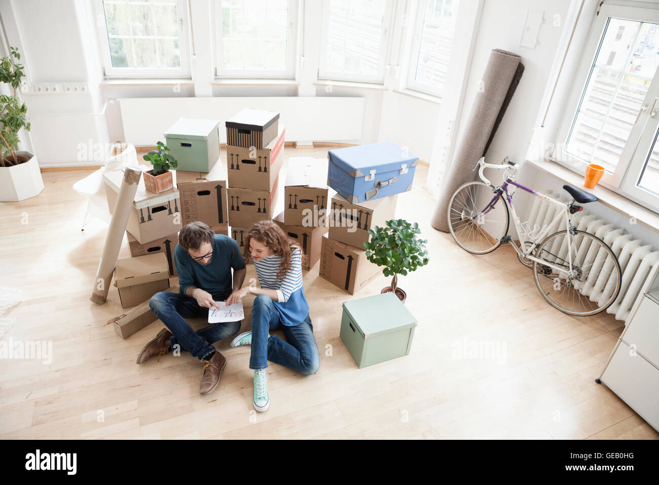 Couple surrounded by cardboard boxes with plan on floor Stock Photo - Alamy