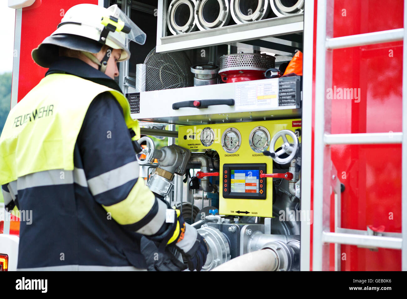 Firefighter at fire engine Stock Photo - Alamy