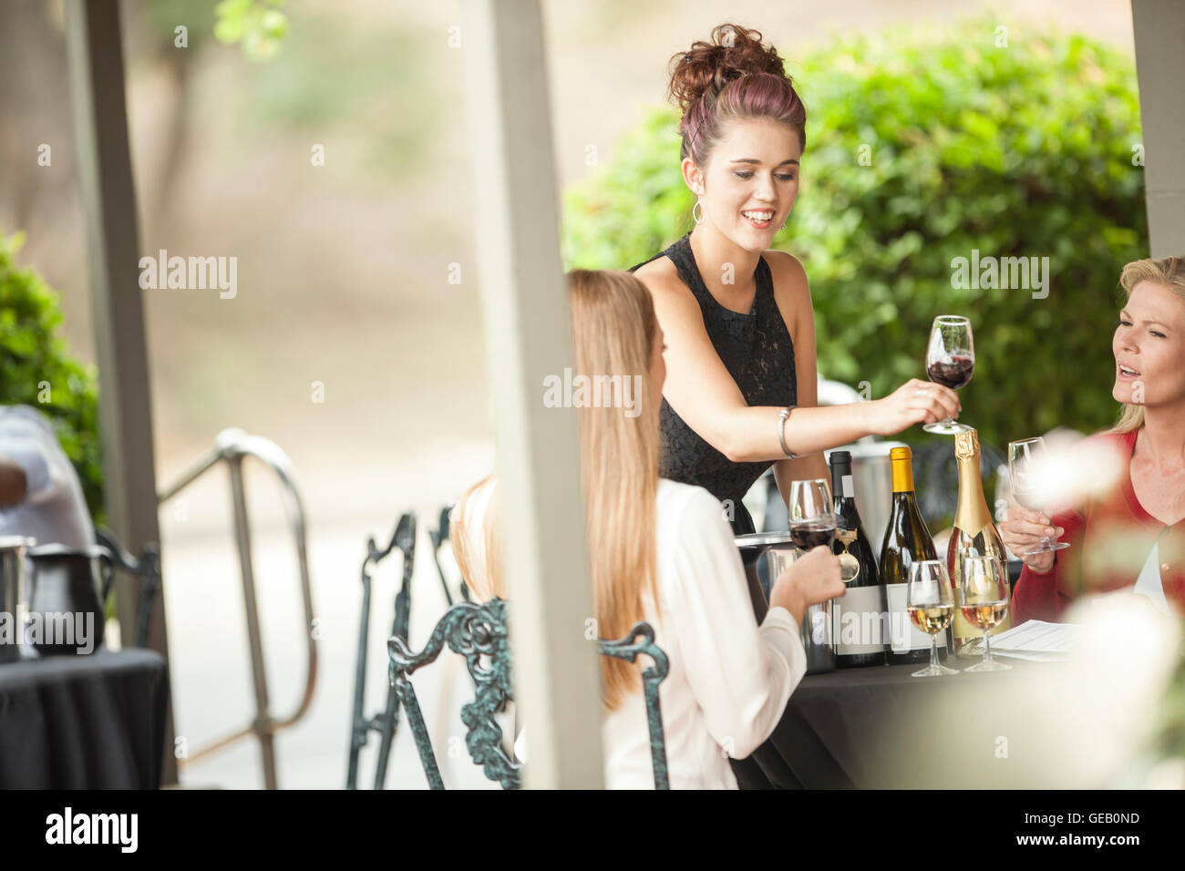 Waitress serving wine in restaurant Stock Photo - Alamy