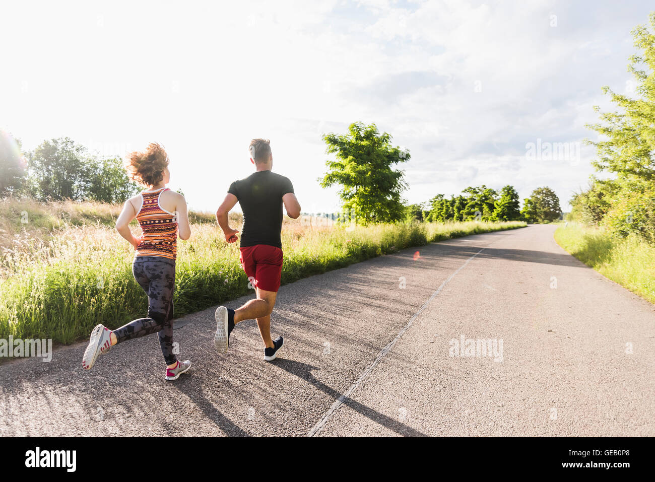 Young couple running on country road Stock Photo - Alamy