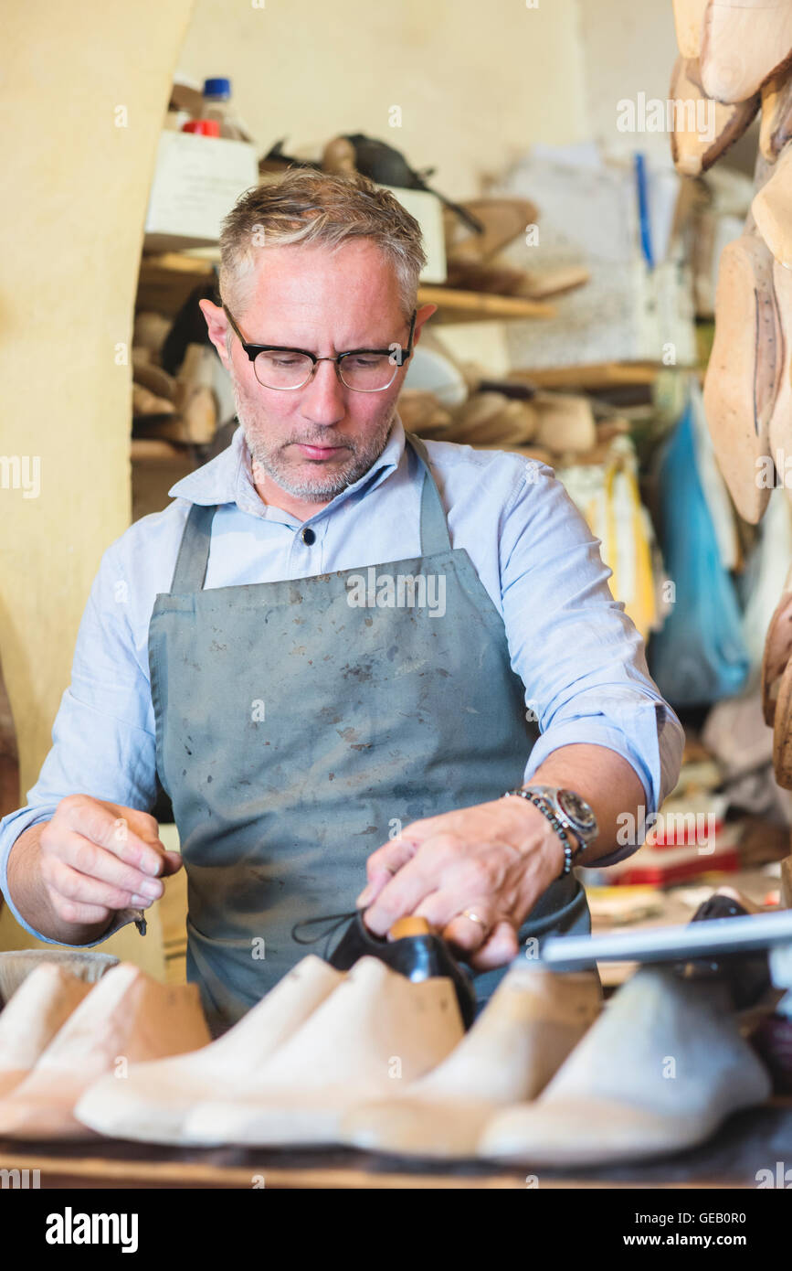 Cobbler making shoes in his workshop Stock Photo - Alamy